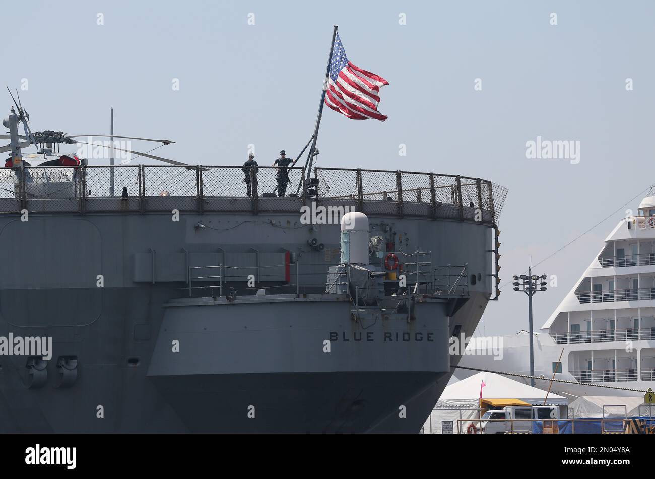 U.S. troopers stand beside their national flag on the USS Blue Ridge ...