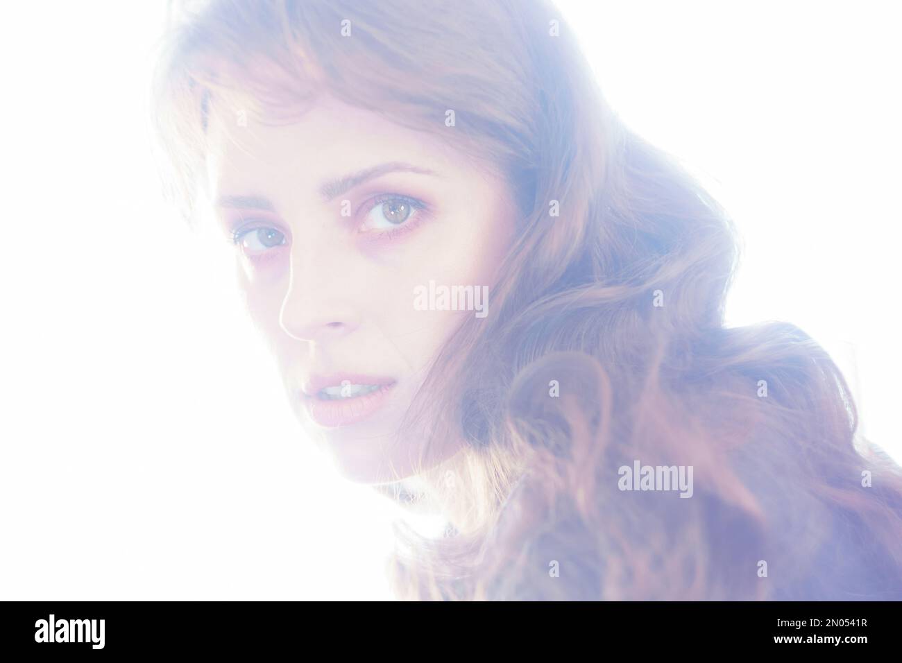 Overexposed portrait of a woman looking scared over her shoulder Stock ...