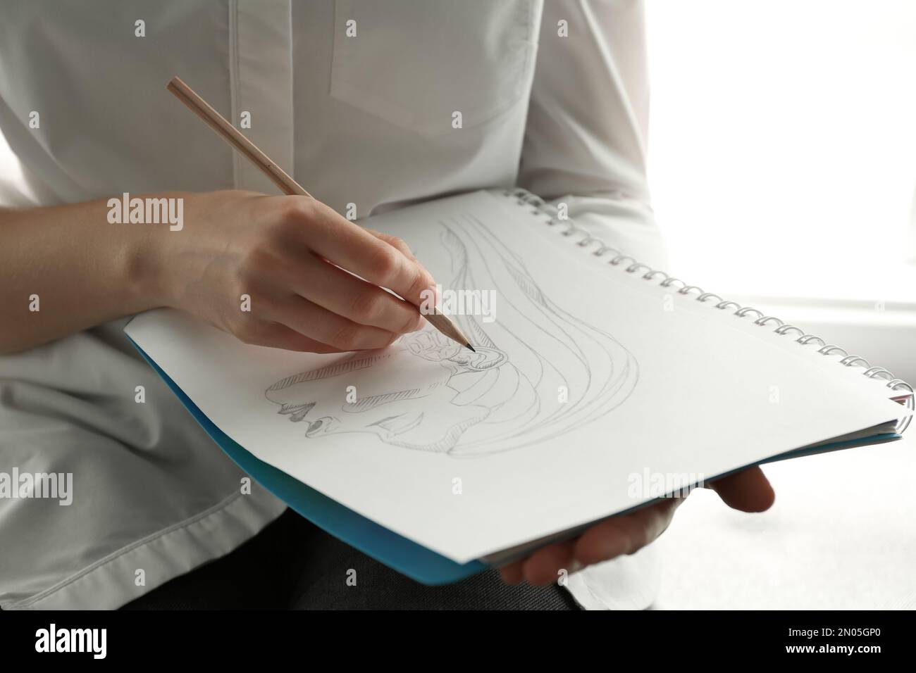 Woman drawing girl's portrait with pencil in notepad, closeup Stock ...
