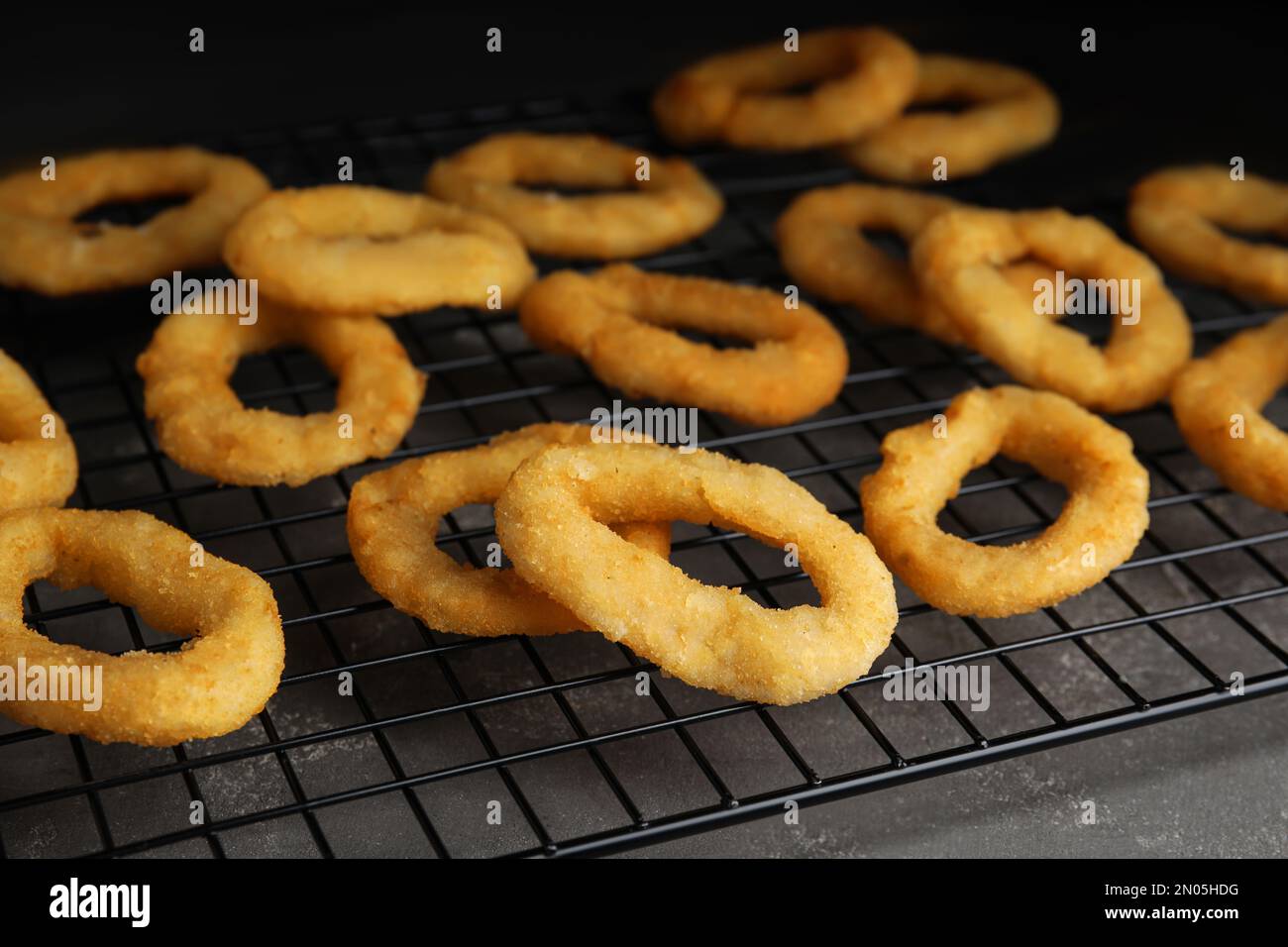 Cooling rack with fried onion rings on grey table Stock Photo - Alamy