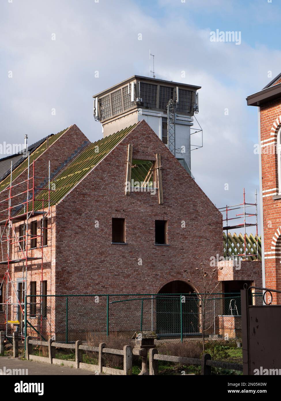 An unfinished new building in a street with scaffolding next to it ...