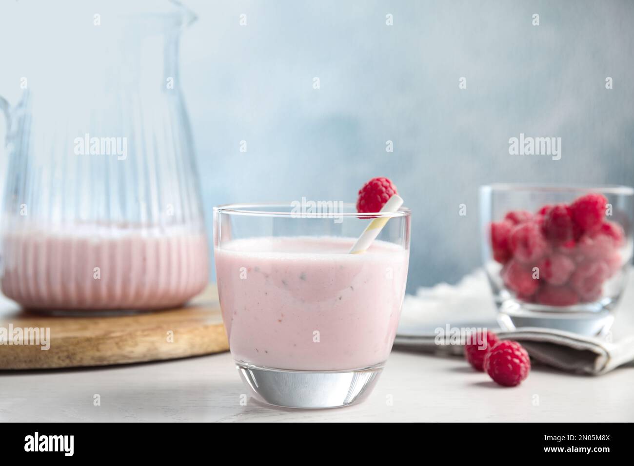 Tasty fresh milk shake with raspberry on white table Stock Photo - Alamy