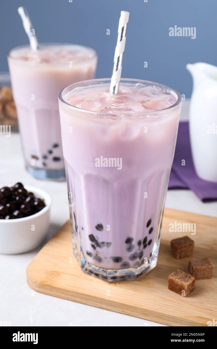 Bubble milk tea with tapioca balls on table against blue background ...