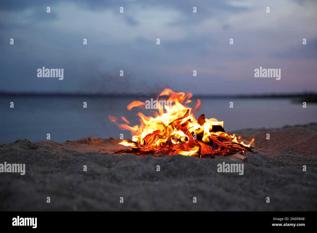 Beautiful bonfire with burning firewood on beach Stock Photo - Alamy