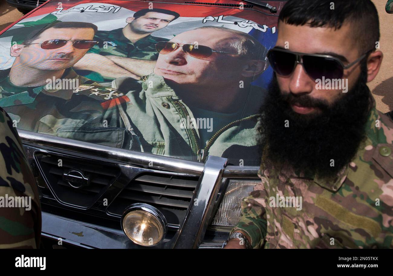 Syrian solder Hassan Muhammad stands near a car covered by a collage ...