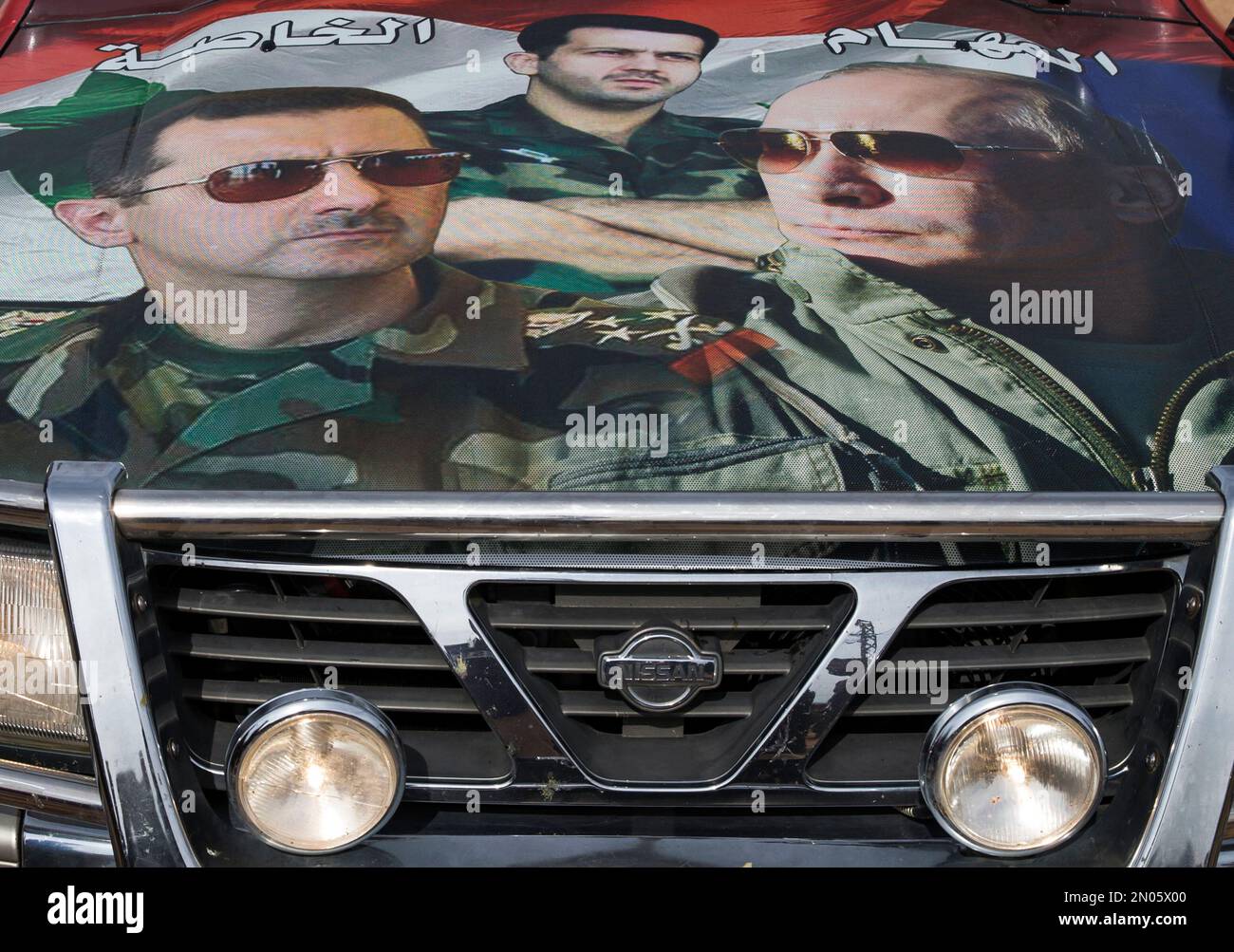 A car covered by a collage showing photos of faces of Russian President ...