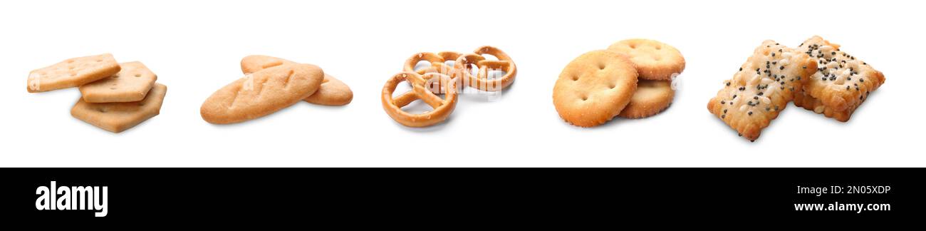 Set of different tasty crispy crackers on white background, banner ...