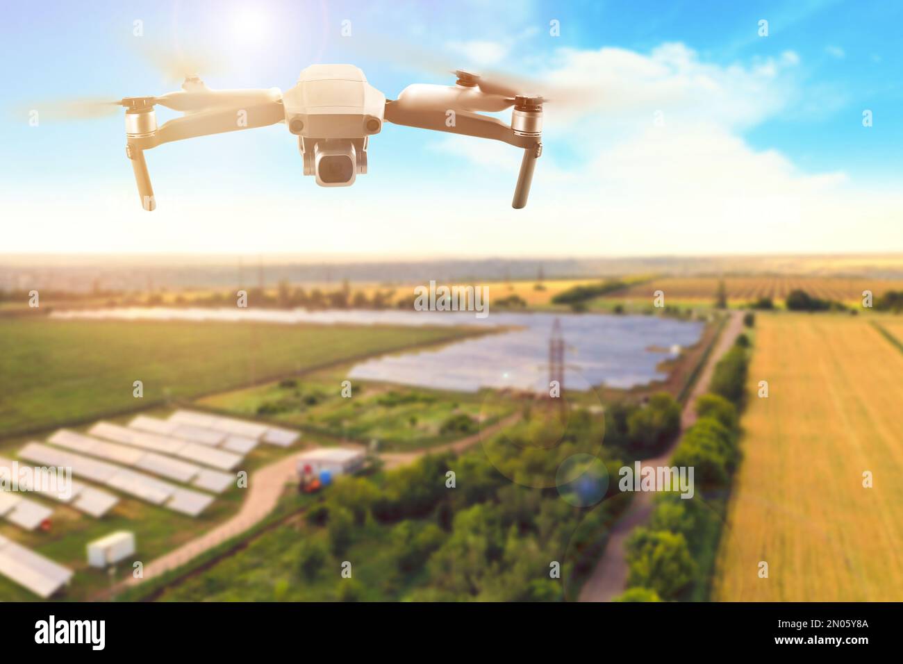Modern drone flying over fields on sunny day. Aerial survey Stock Photo ...
