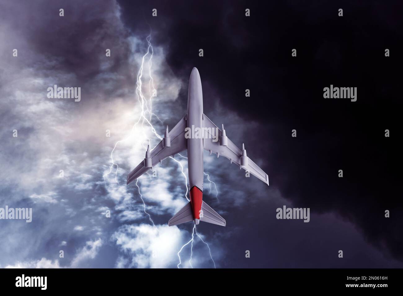 Airplane flying in cloudy sky during thunderstorm Stock Photo - Alamy