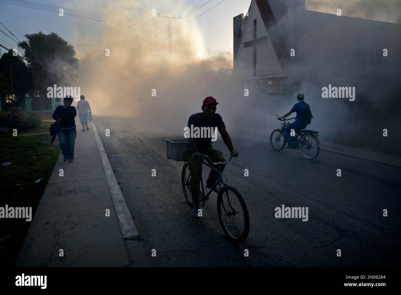 People make their way through fumigation fog, sprayed to kill Aedes ...