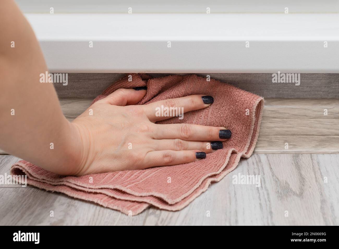 a woman washes the floor in a hard-to-reach place. woman doing wet ...