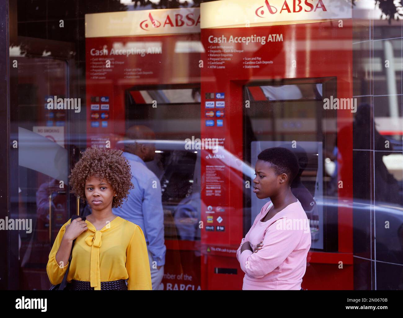 Woman stand outside a building used by South Africa's ABSA bank in Cape ...
