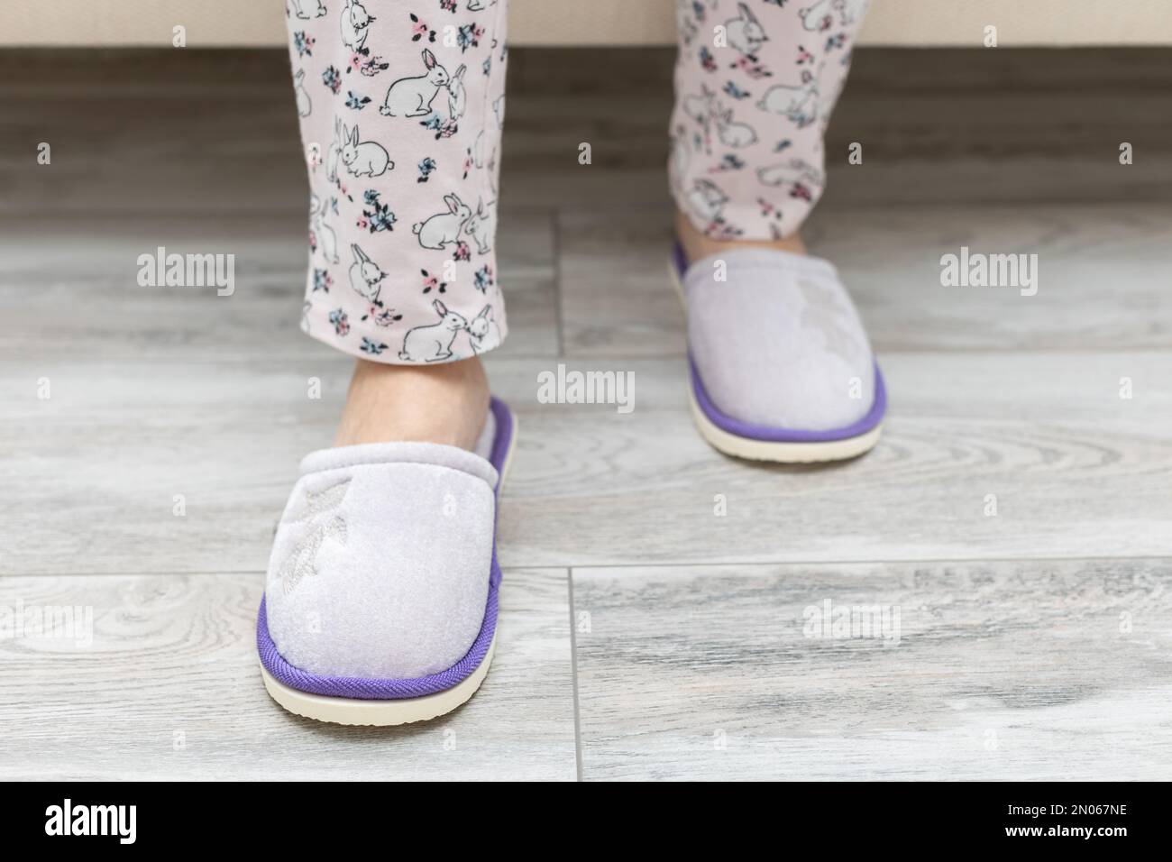 Woman puts on slippers sitting on the bed. man after waking up sitting ...