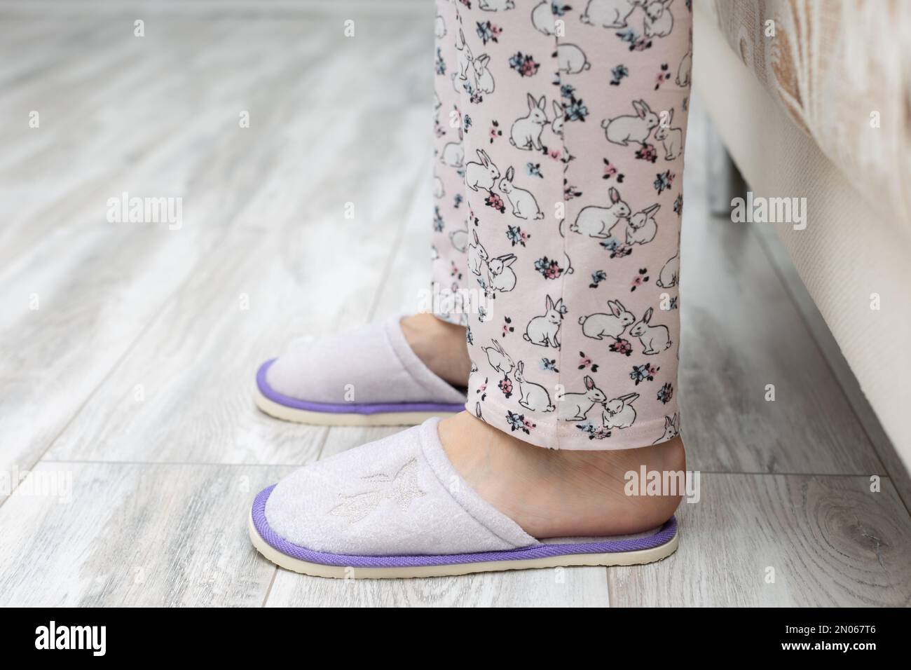 man puts on slippers sitting on the bed. Woman in pajamas. man wakes up ...