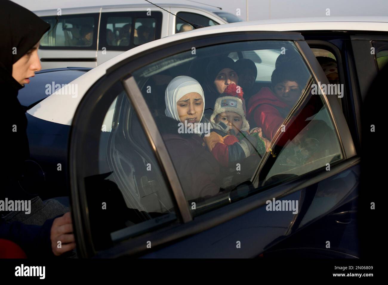 Syrian refugees get in a taxi as they make their way to the Greek ...