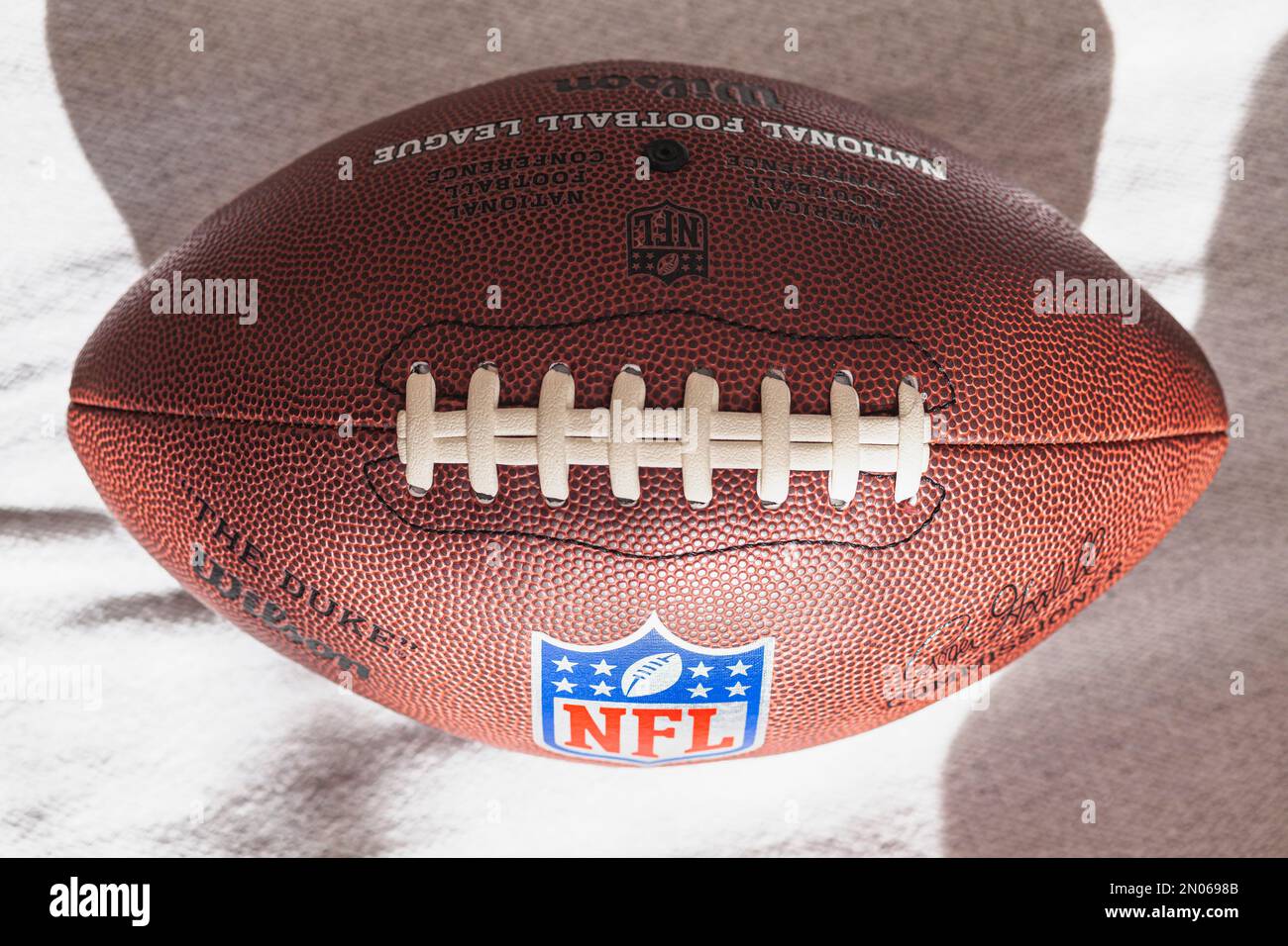 Top view of a NFL Wilson Duke ball over a white sofa in a home. Sun ...