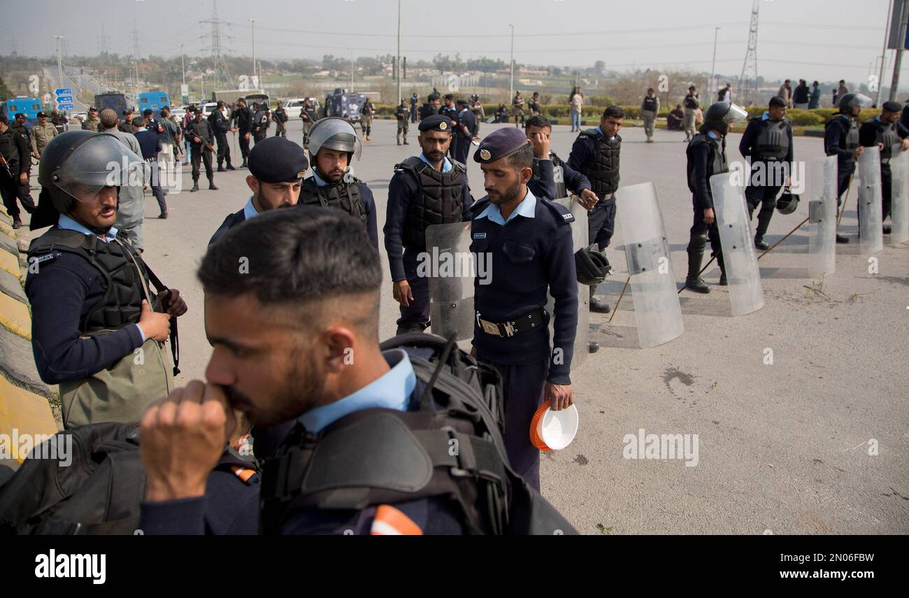Pakistani police officers and security personnel stand guard as ...