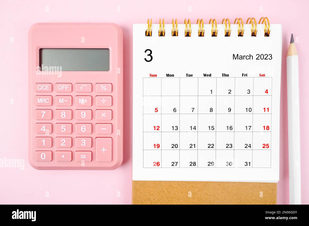 March 2023 desk calendar for 2023 year with calculator on pink color ...