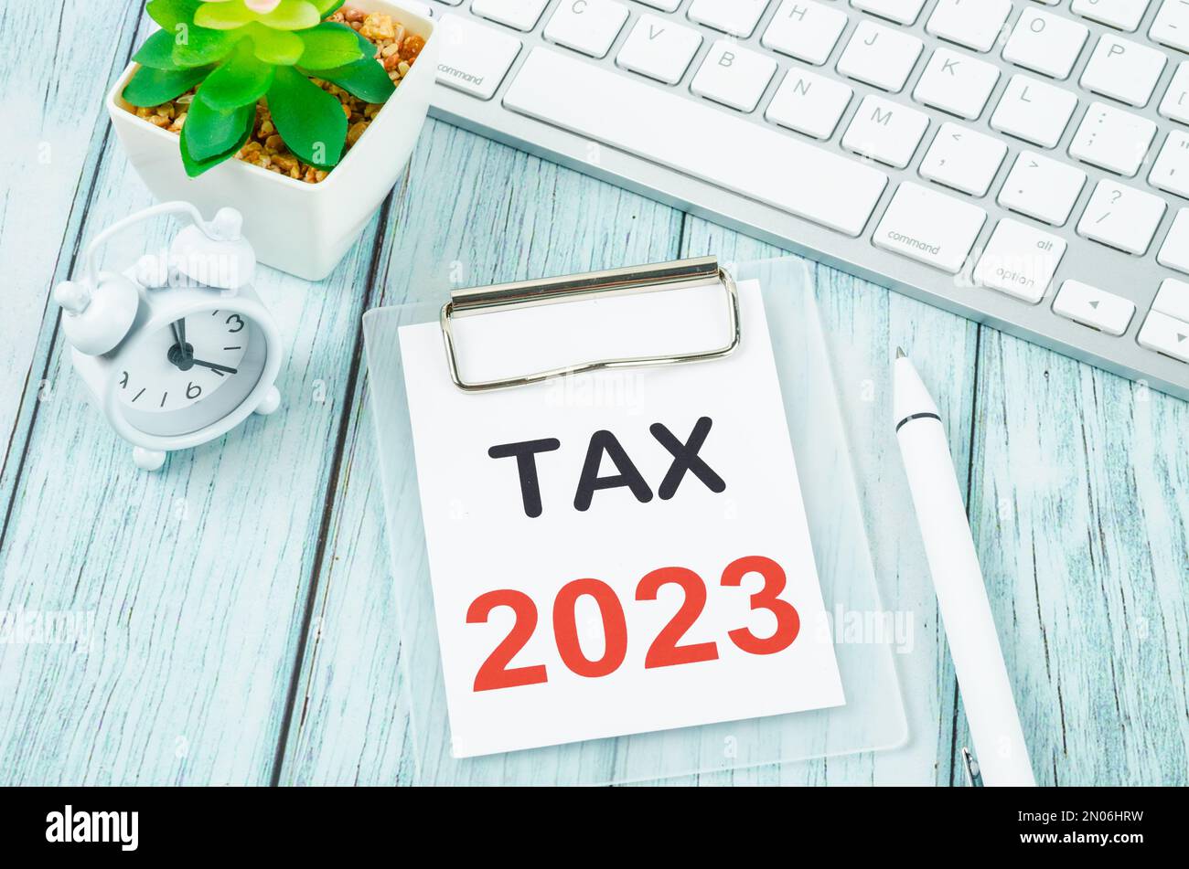 Tax 2023 text on clipboard with pen and calculator on wooden background ...