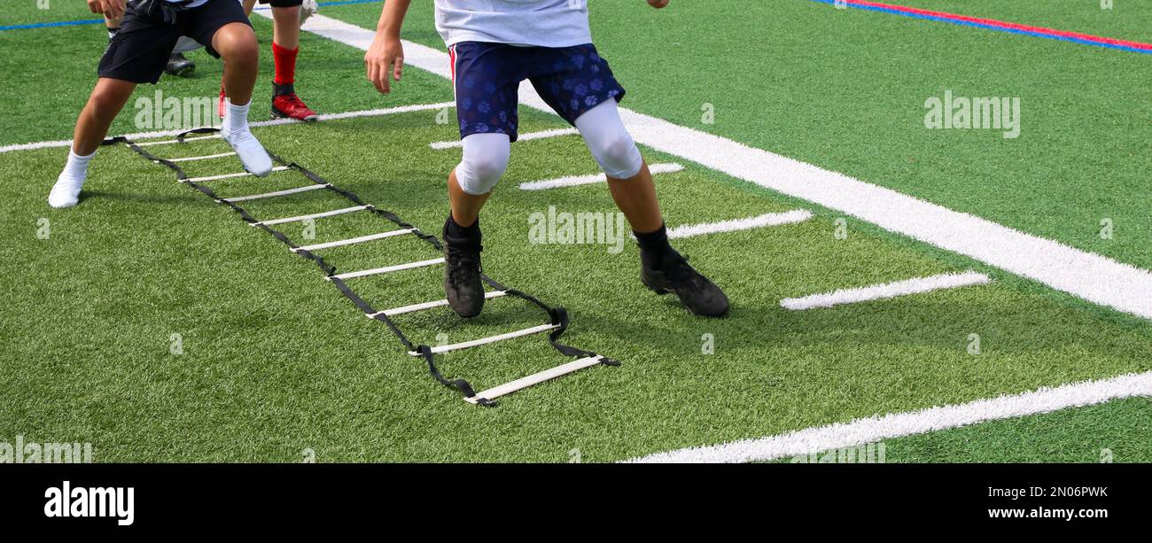 Front view of the legs of high school boys running over the ladder on a ...