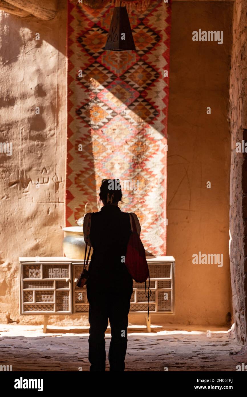 A vertical of a tourist looking at an old carpet with traditional ...