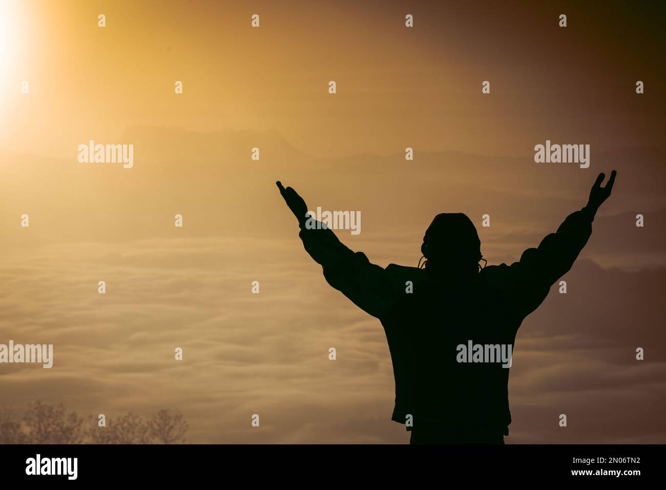 Man praying at sunset mountains raised hands Travel Lifestyle spiritual ...