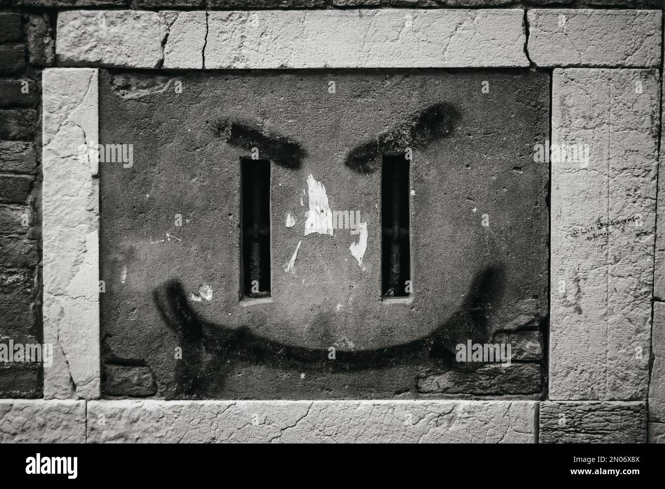 A simple graffiti of a smiling face on a street wall, grayscale Stock ...