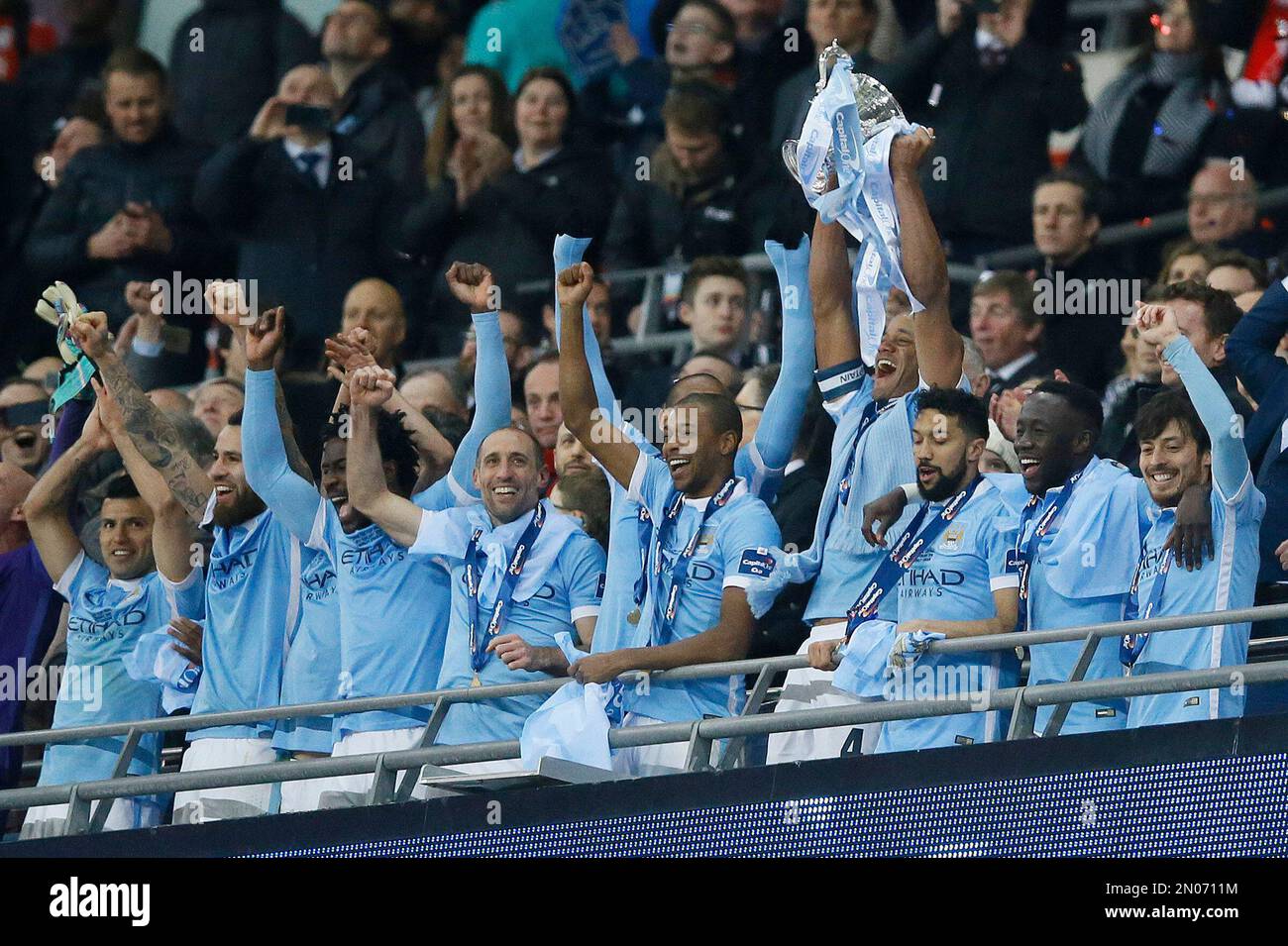 Manchester City's Vincent Kompany raises the trophy after winning the ...