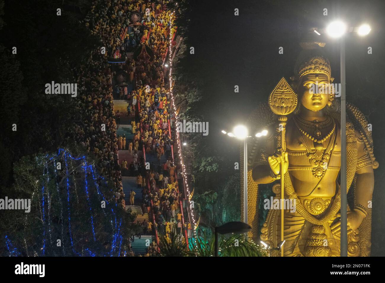 Thousands of Hindu devotees seen on a stair behind the giant Murugan ...