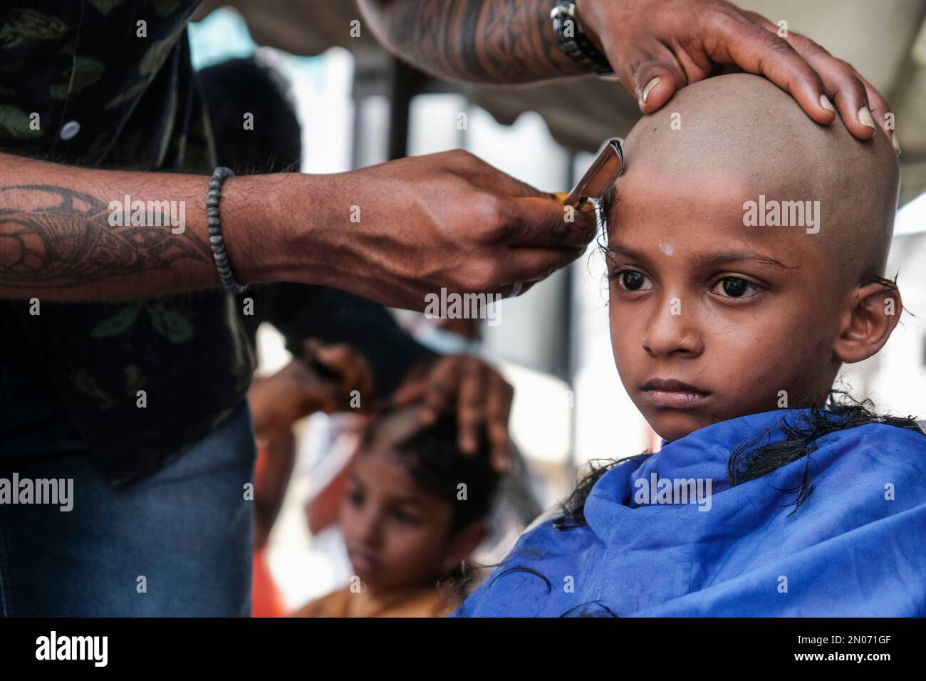 Batu Caves, Malaysia. 05th Feb, 2023. A barber seen shaving a young boy ...