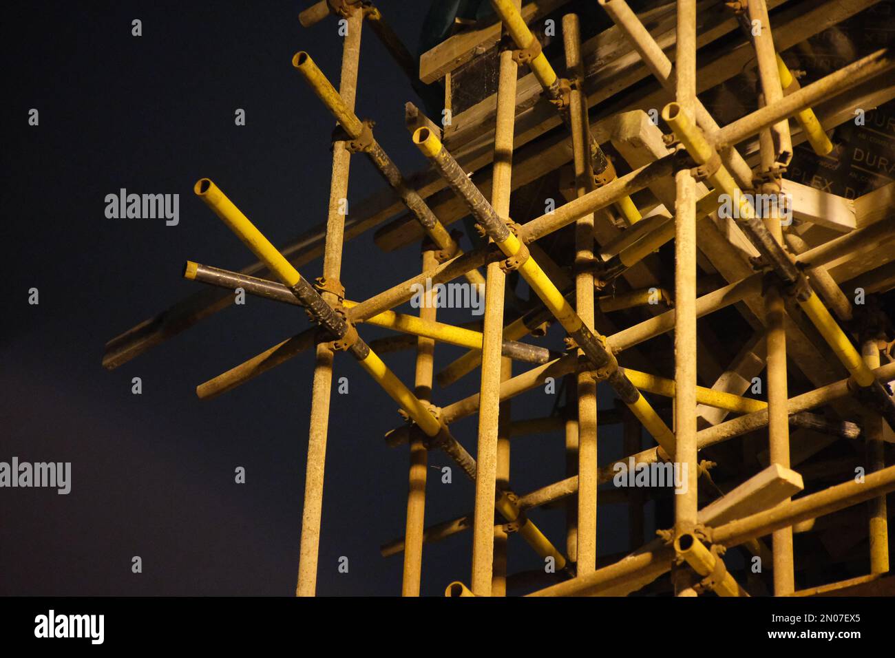 Yellow scaffolding under street lamp light at night Stock Photo - Alamy