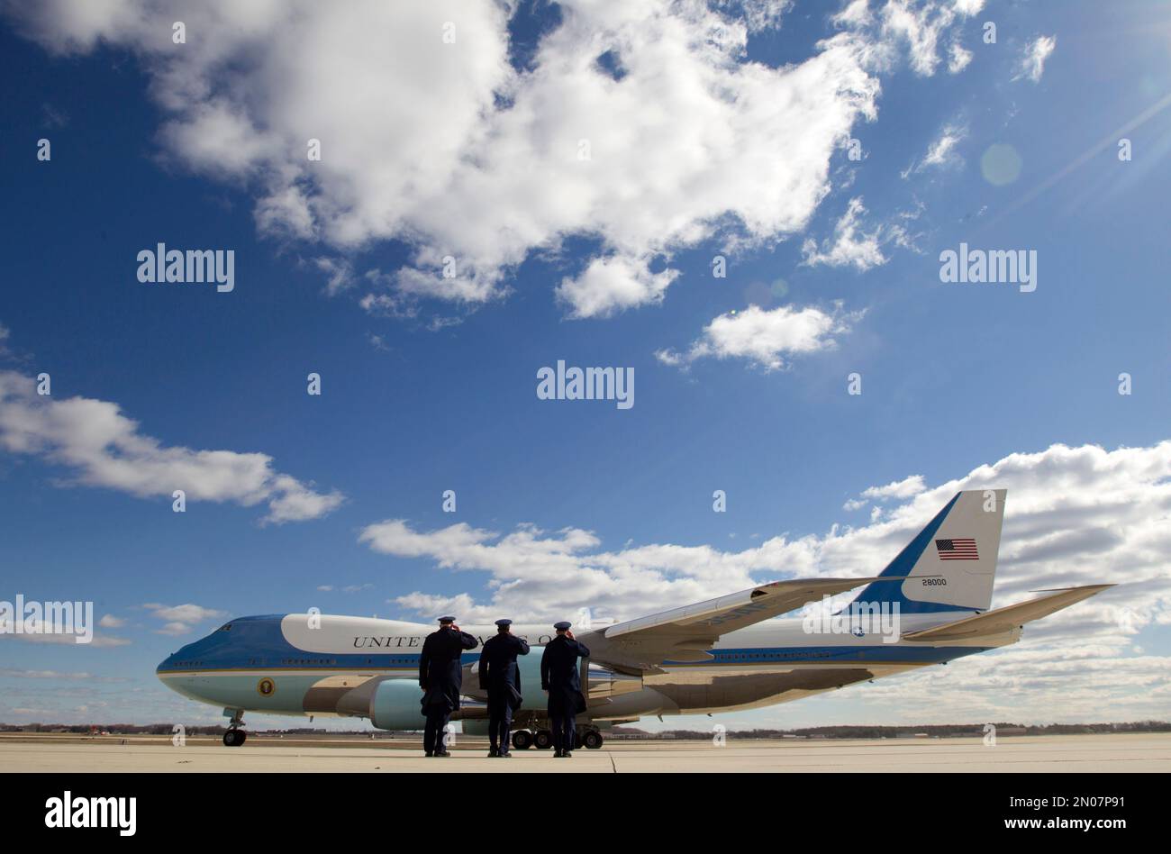 Military personnel salute as Air Force One, with President Barack Obama ...