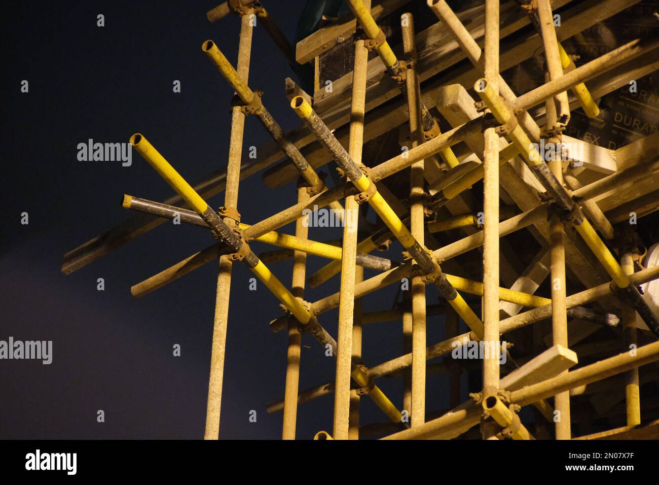 Yellow scaffolding under street lamp light at night Stock Photo - Alamy