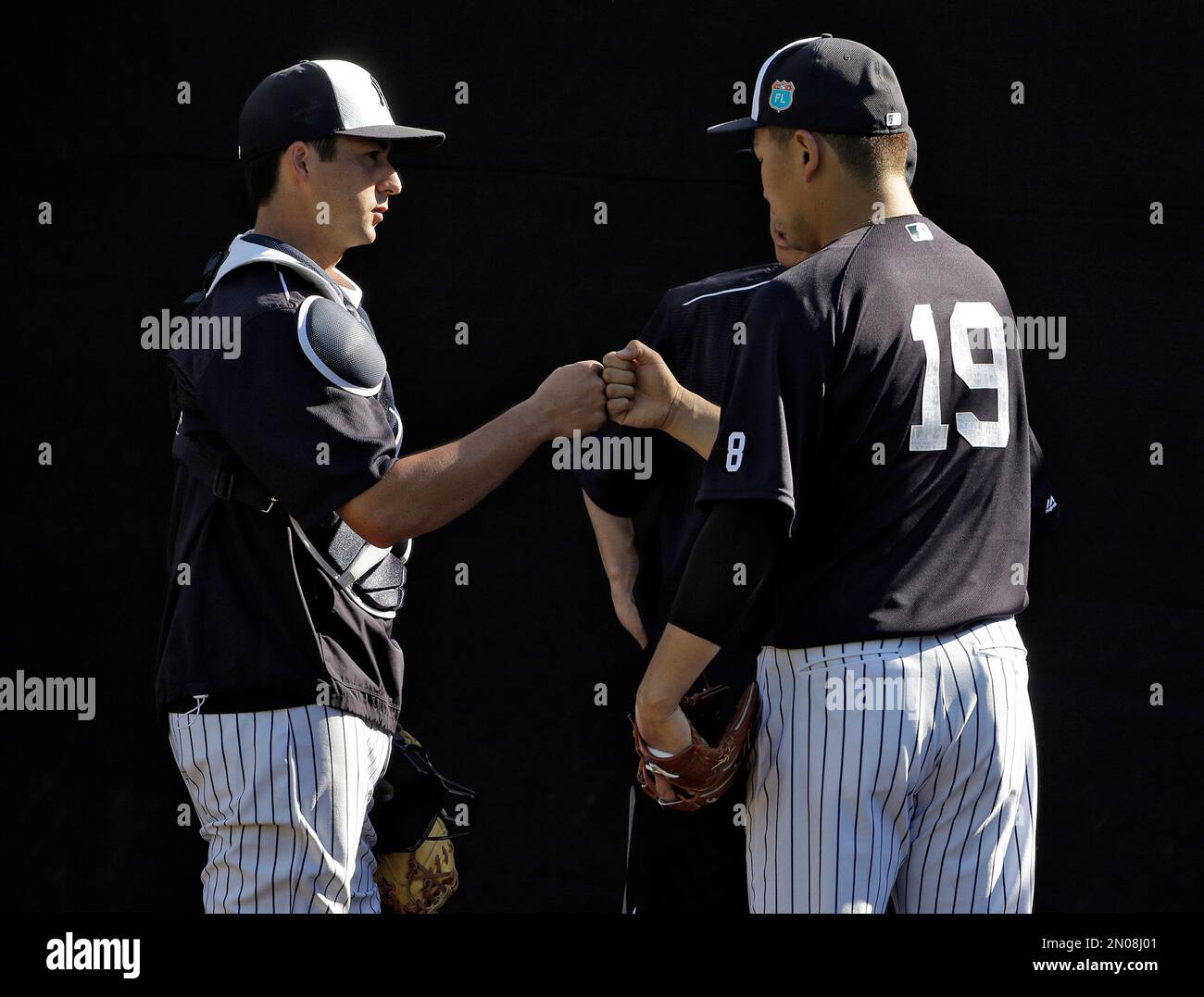 New York Yankees pitcher Masahiro Tanaka, of Japan, right, fist bumps ...