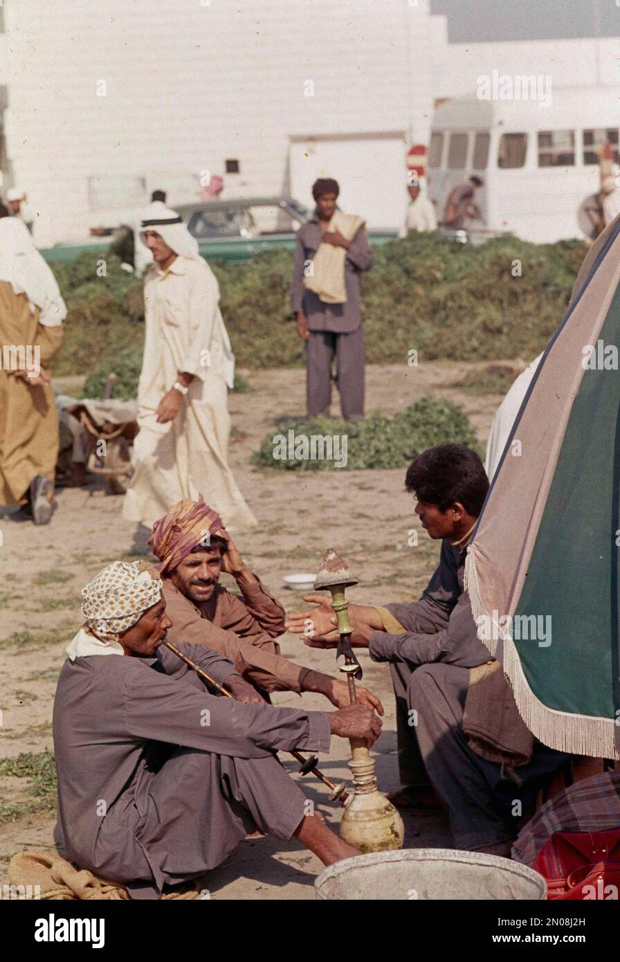Men smoke a shisha in Qatar, 1977. (AP Photo/Bob Dear Stock Photo - Alamy