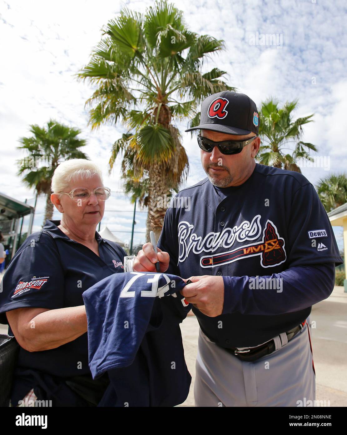 Atlanta Braves manager Fredi Gonzalez, right, signs an autograph for a ...