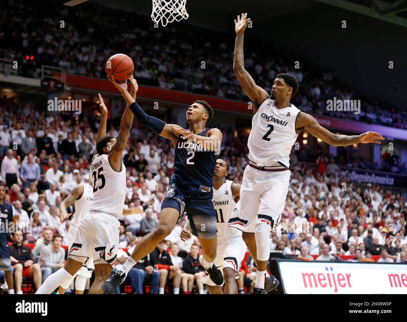Connecticut guard Jalen Adams, center, shoots between Cincinnati's ...