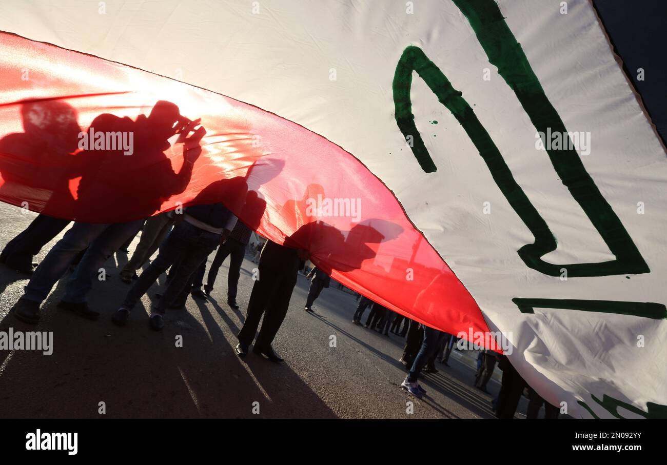 Iraqi protesters chant slogans as they wave national flags during a ...