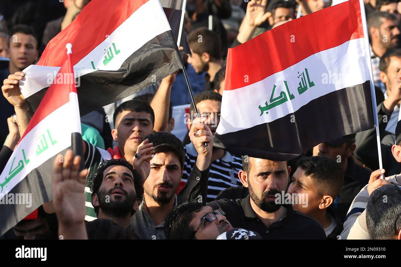 Iraqi protesters chant slogans as they wave national flags during a ...