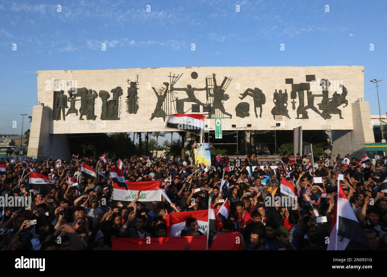 Iraqi protesters chant slogans as they wave national flags during a ...