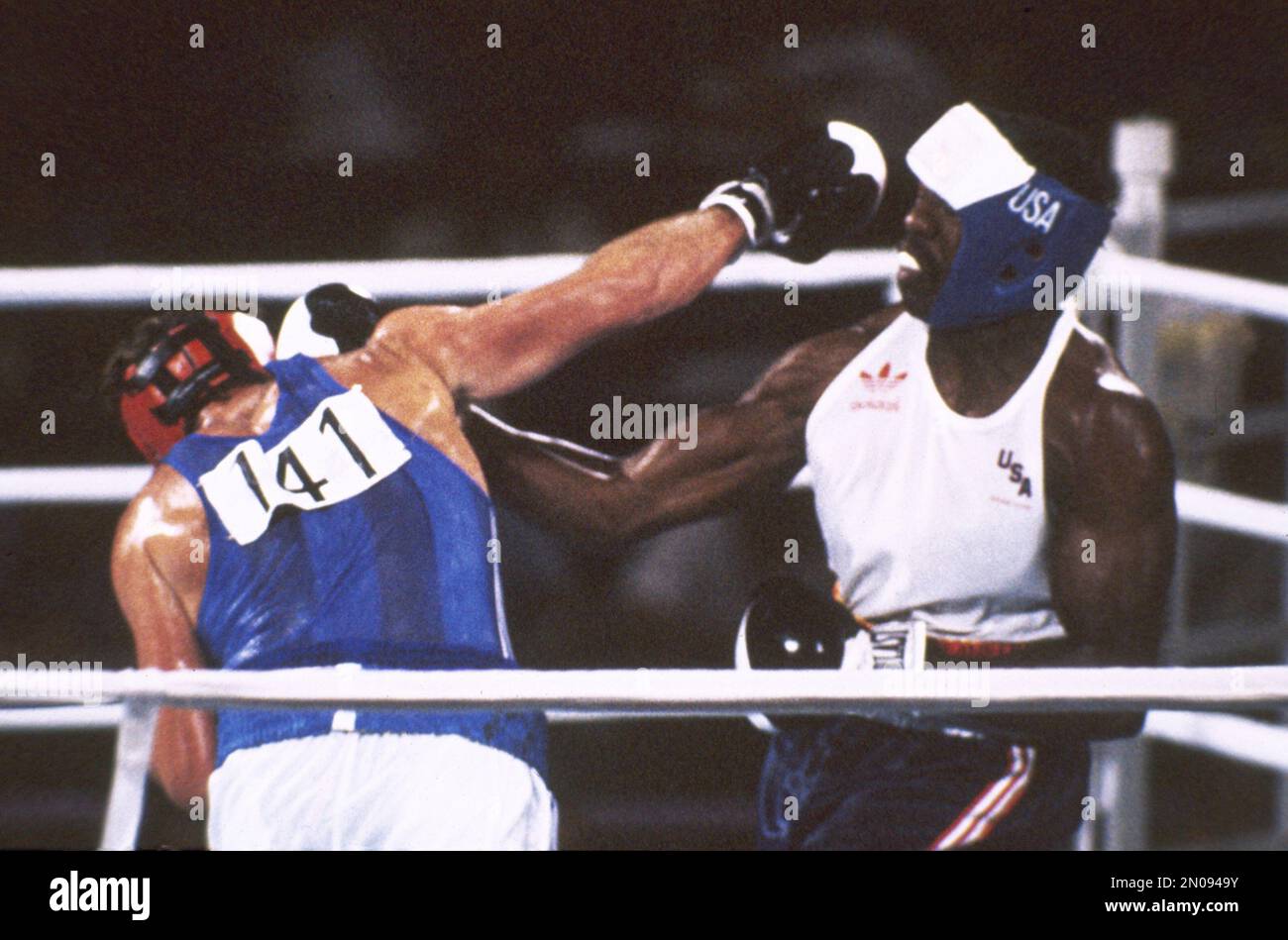 American boxer Henry Tillman lands a punch to the head of Italian boxer ...