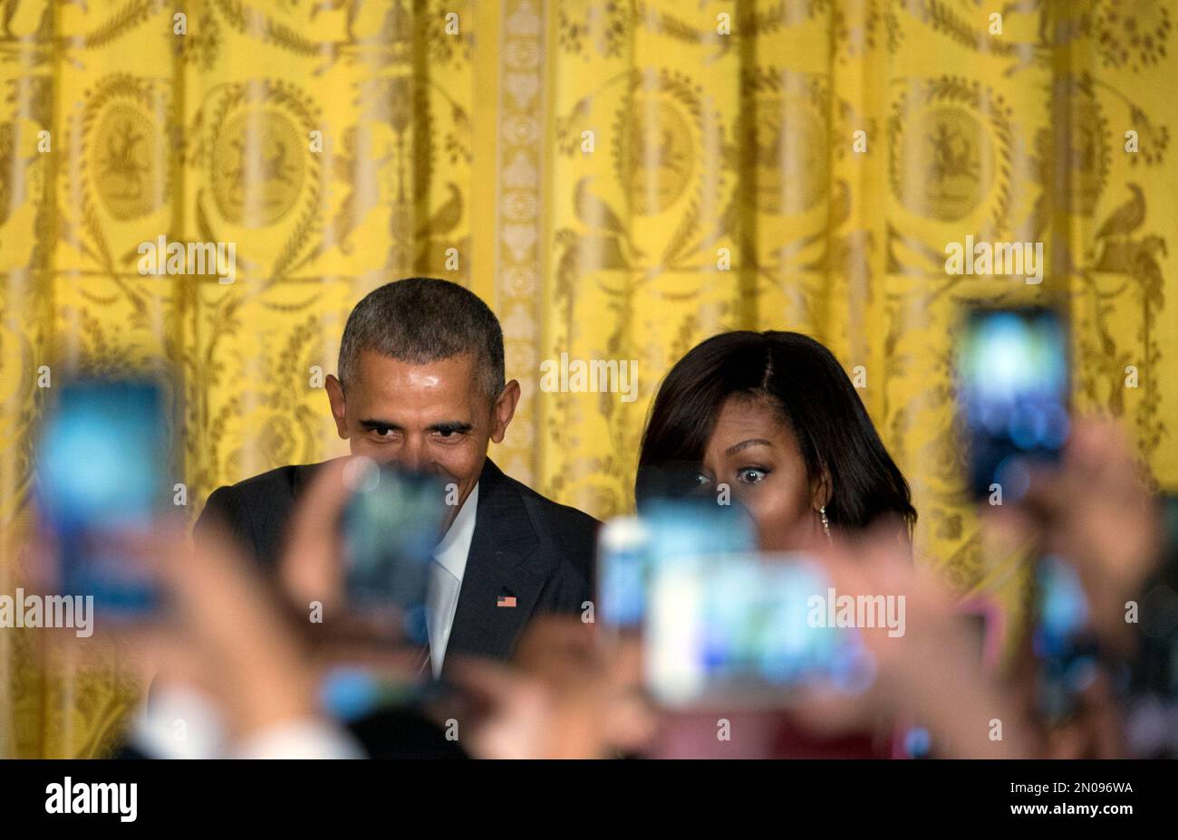 President Barack Obama and first lady Michelle Obama peek out above ...