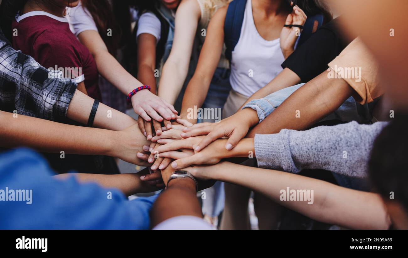Multicultural teenagers putting their hands together in a huddle. Group ...
