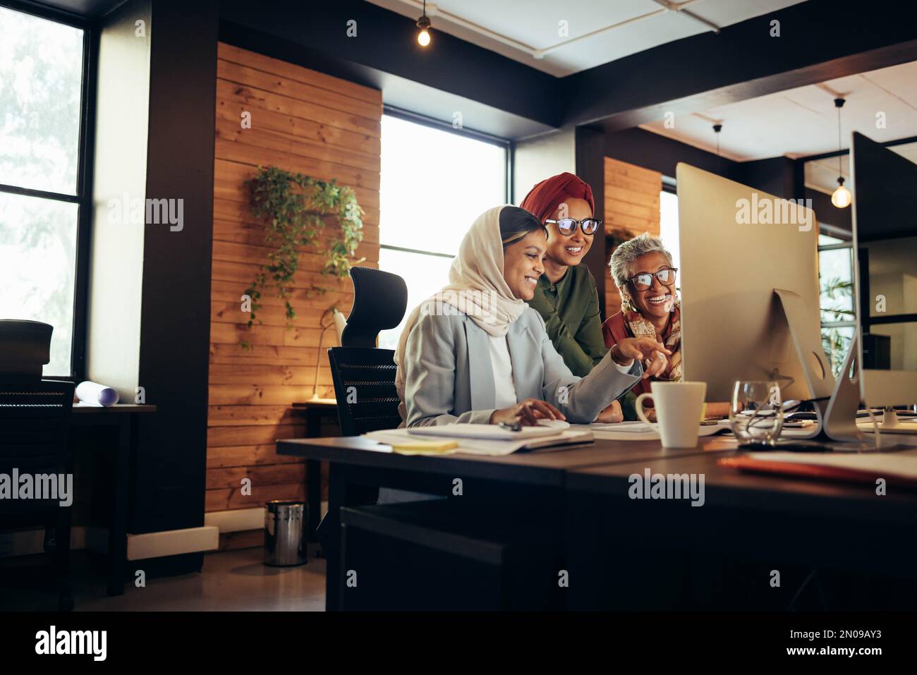 Cheerful businesswomen working as a team in a modern office. Group of ... Cheerful businesswomen working as a team in a modern office. Group of ...