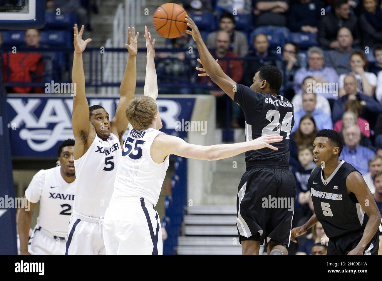 Providence's Kyron Cartwright (24) passes over Xavier's J.P. Macura (55 ...