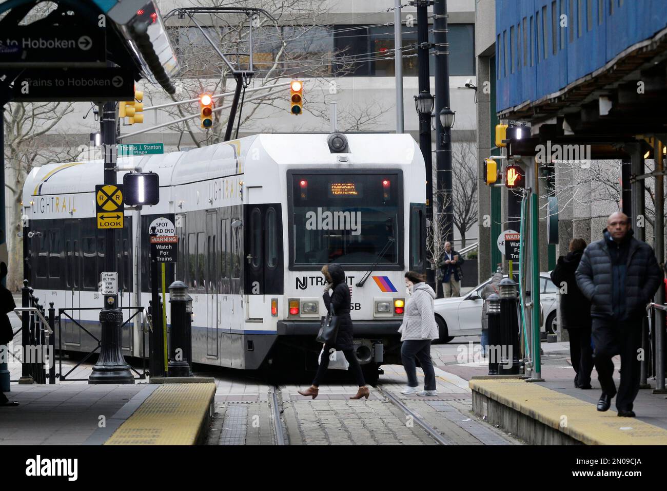 Commuters walk across the tracks at the Exchange Place stop on the ...