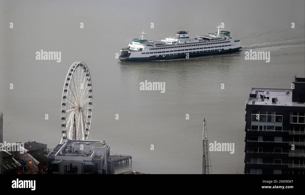 A Washington state ferry passes the Seattle Great Wheel as it ...
