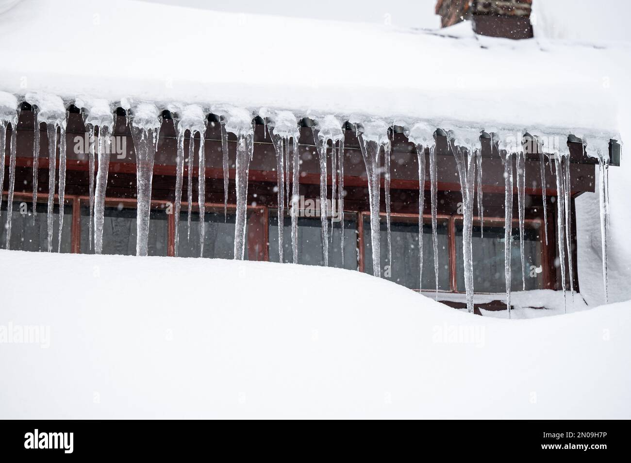 Dangerous sharp icicles and snow hanging from the roof. Dangerous ...