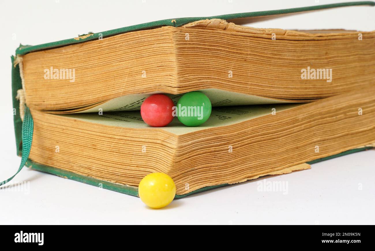 hard candy bewtween pages of an old book Stock Photo - Alamy