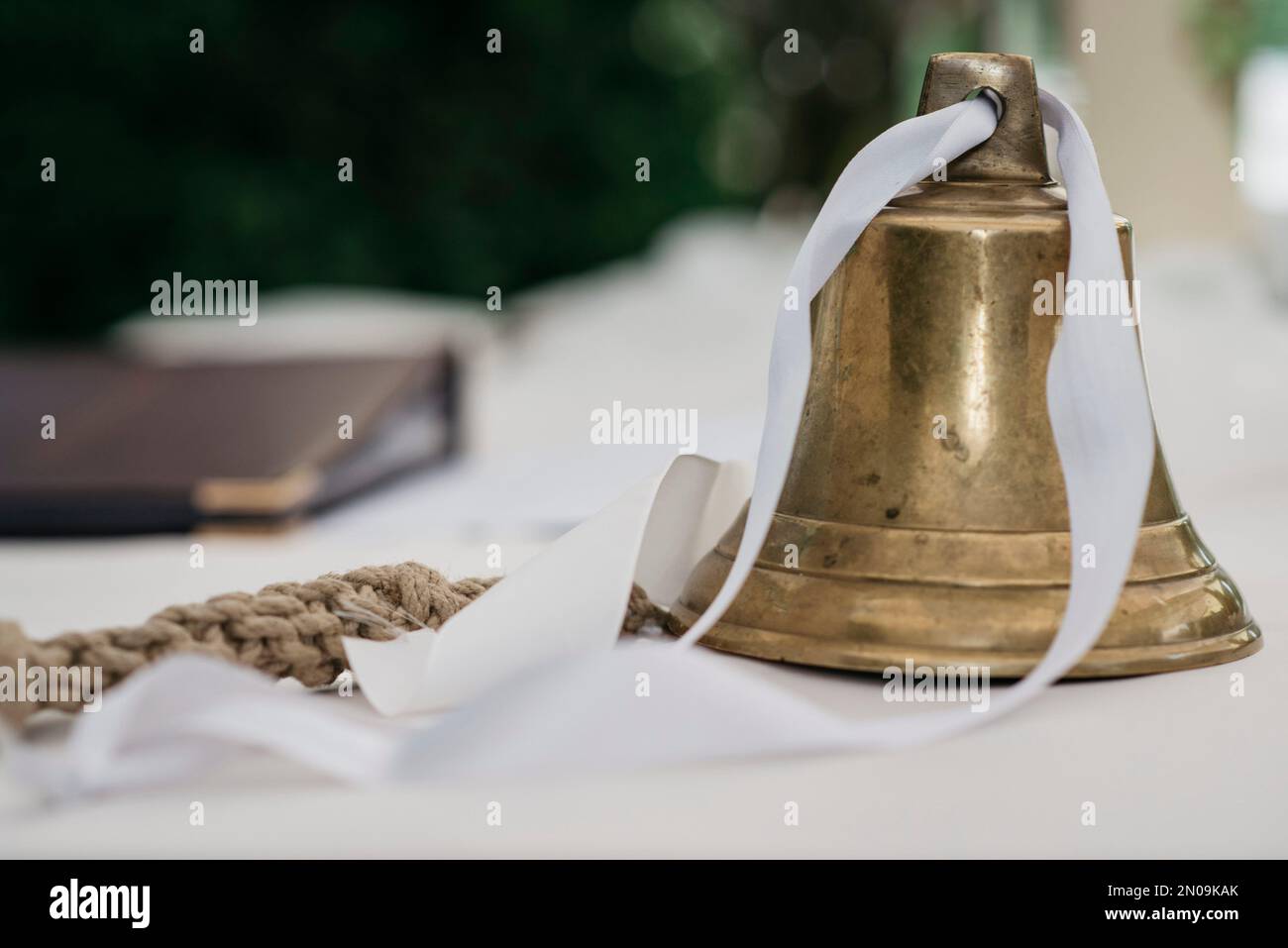 A vintage bell with a white ribbon on a table Stock Photo - Alamy